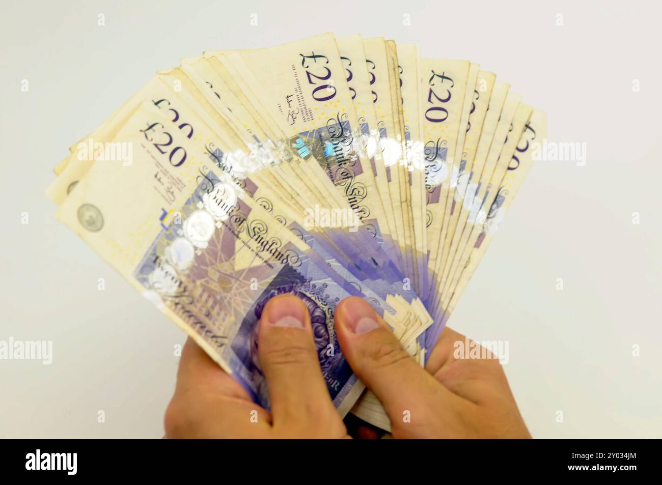 Close up view of male hand holding a bunch of pounds Stock Photo - Alamy