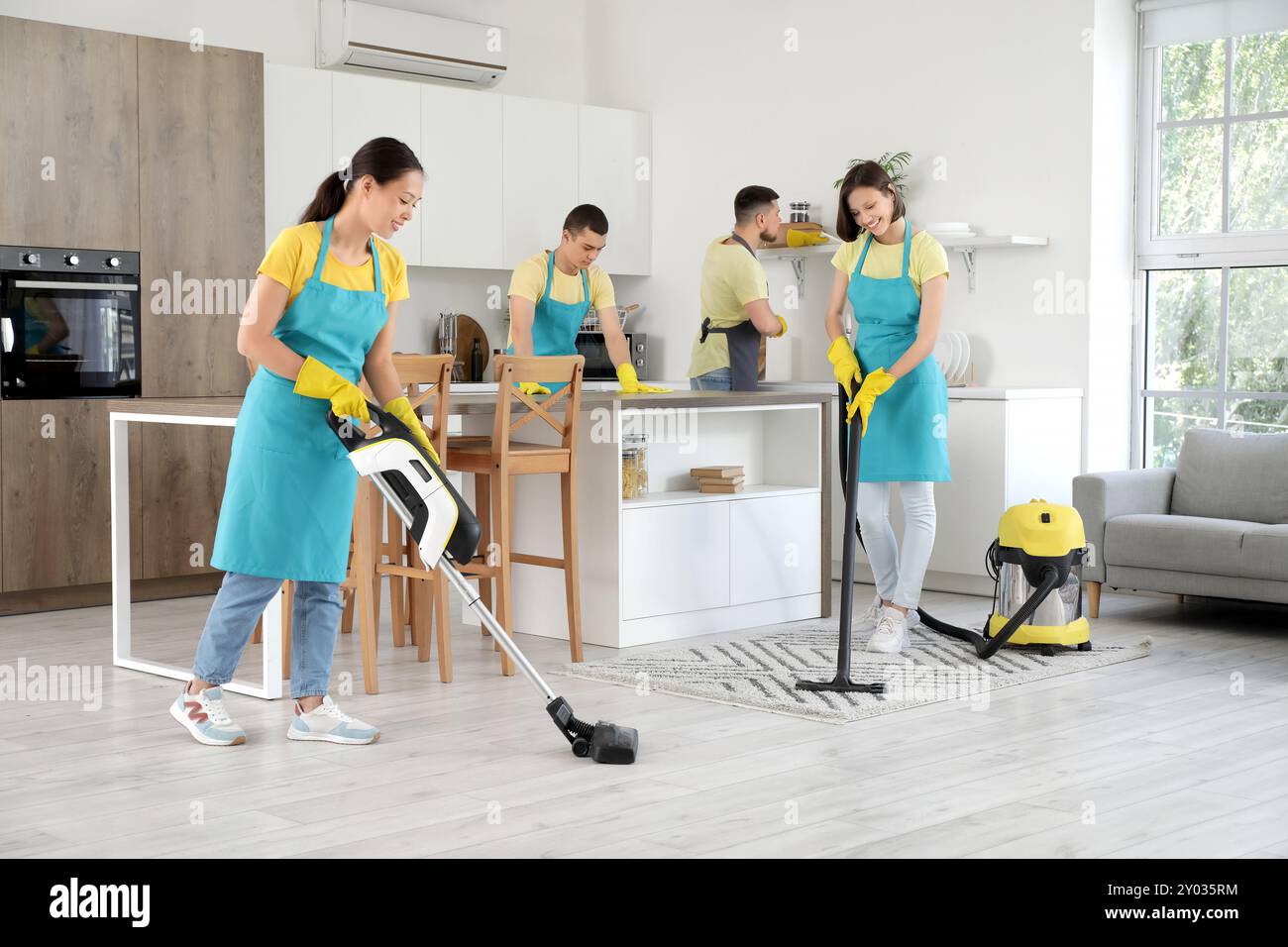 Group of young janitors cleaning in kitchen Stock Photo - Alamy