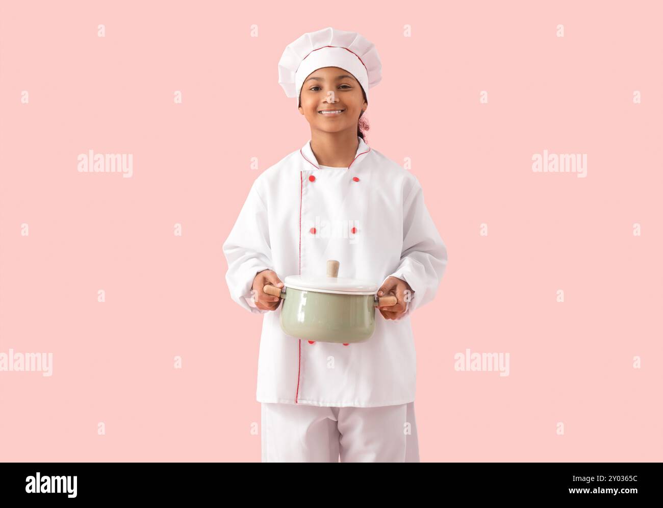 Teenage African-American chef with cooking pot on pink background Stock ...
