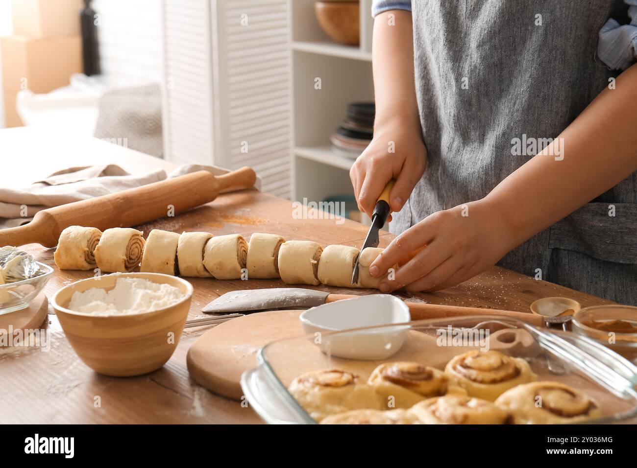 Woman preparing traditional cinnamon rolls in kitchen Stock Photo - Alamy