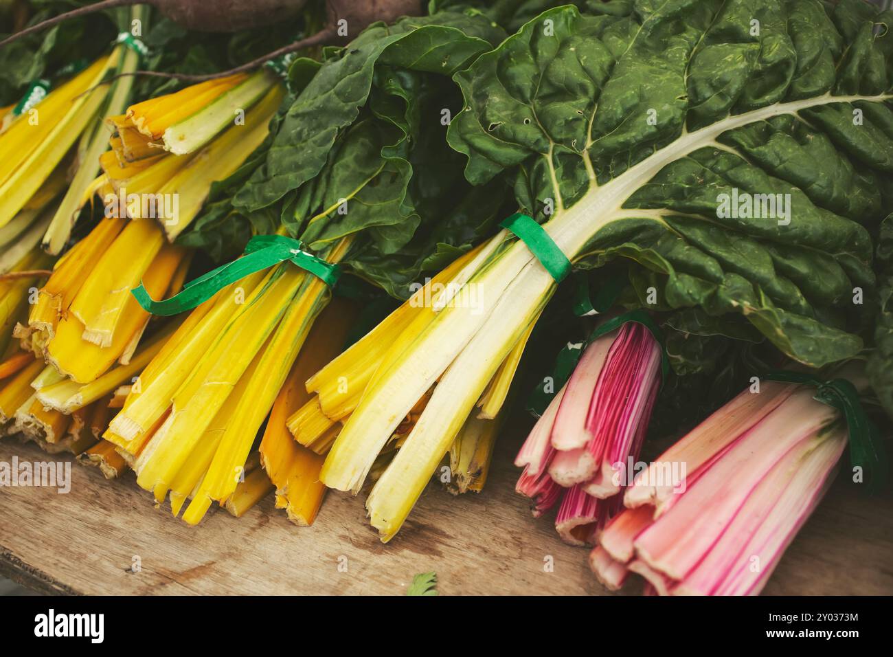 A top down view of a table full of swiss chard bundles, on display at a ...