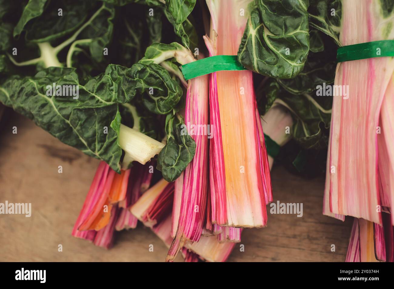 A top down view of a table full of swiss chard bundles, on display at a ...