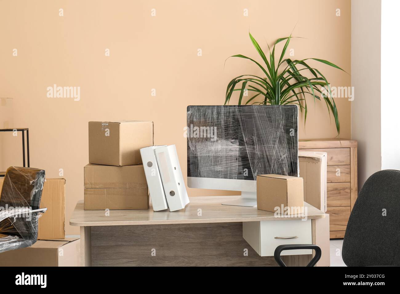 Wrapped computer monitor with moving boxes on desk in office Stock ...