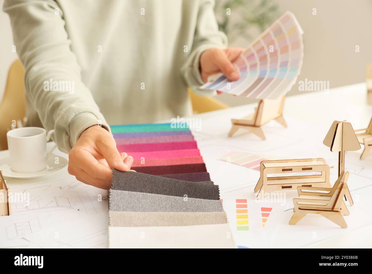 Male furniture designer with color palettes ad fabric samples working ...