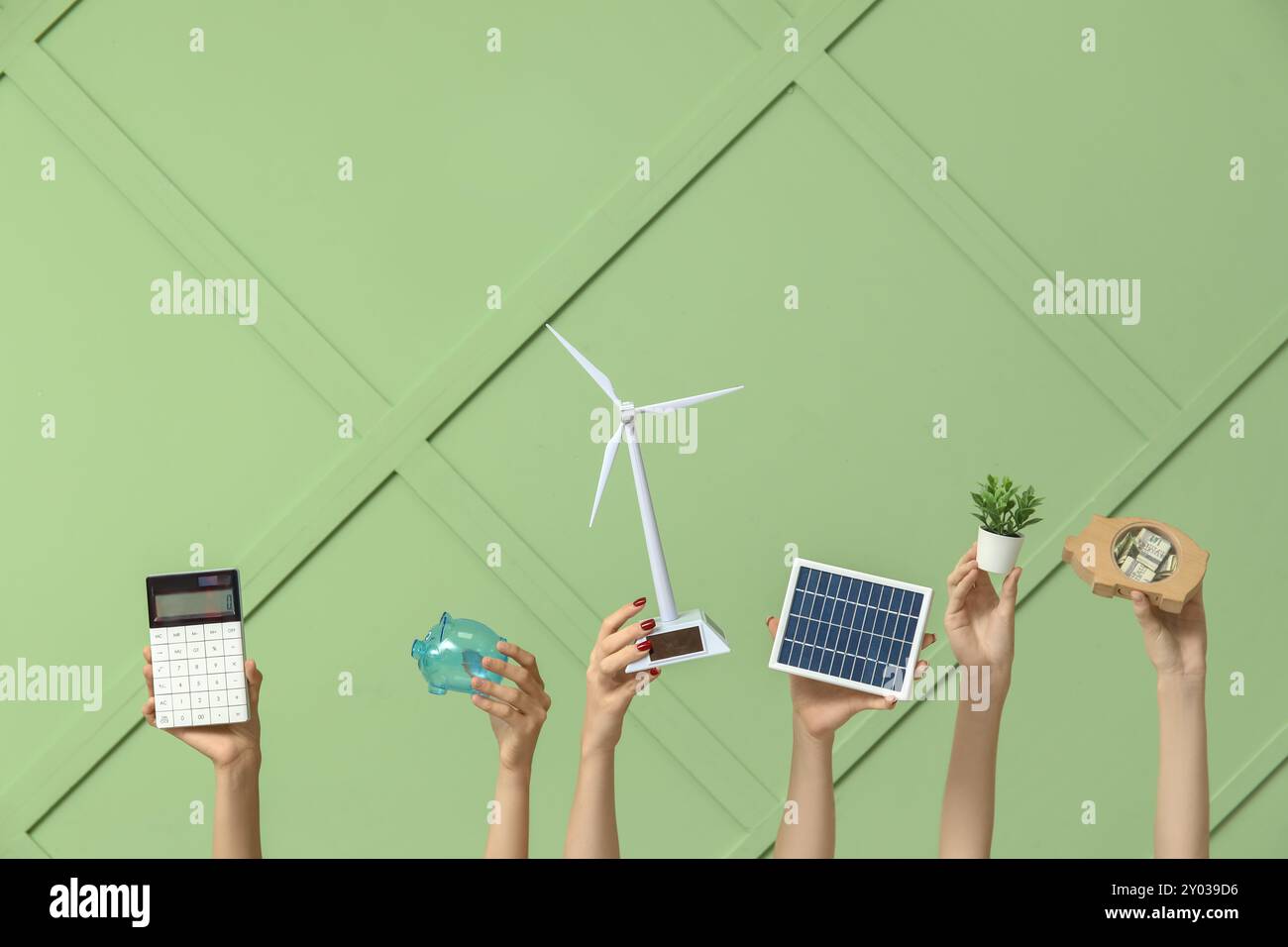 Many hands with wind turbine model, piggy banks and solar panel on ...