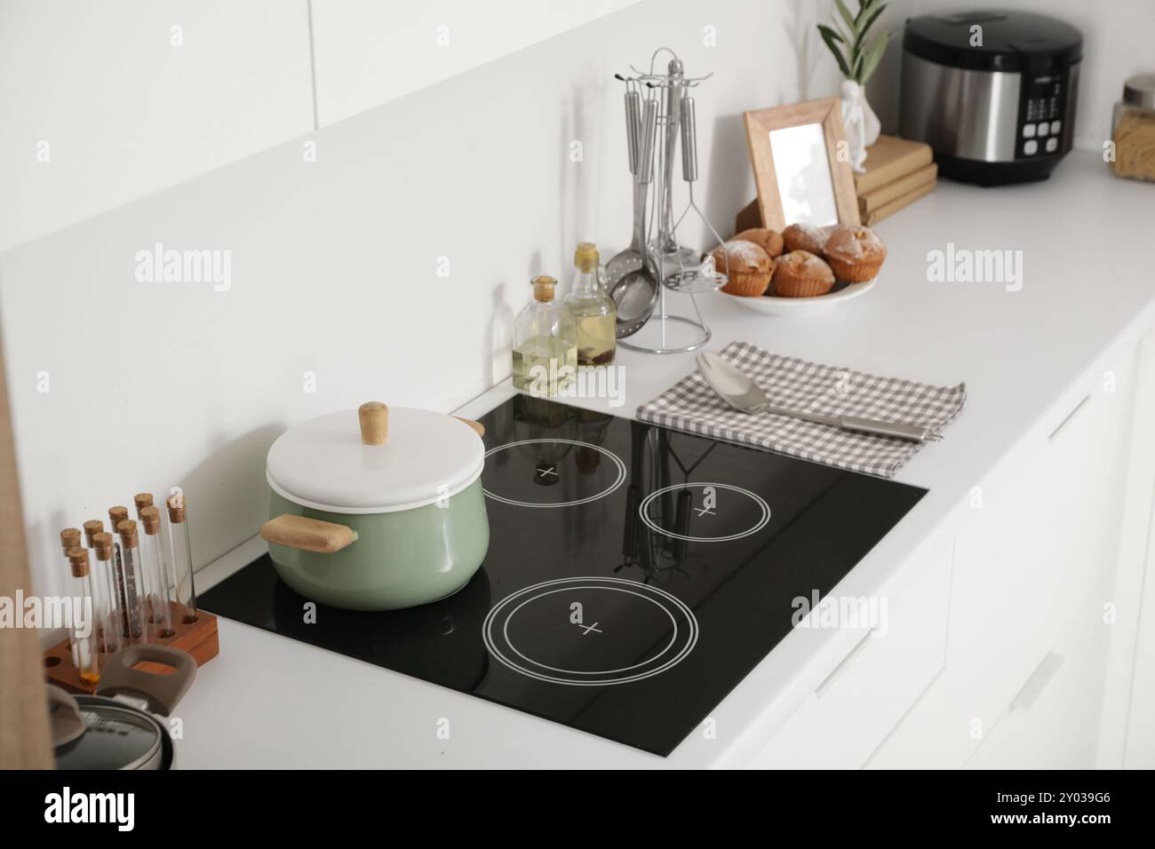 Cooking pot on stove with utensils in light kitchen Stock Photo - Alamy