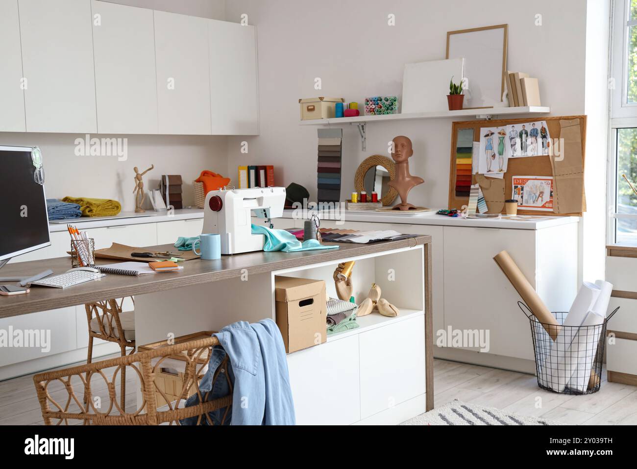 Interior of fashion designer's studio with workplace and sewing ...
