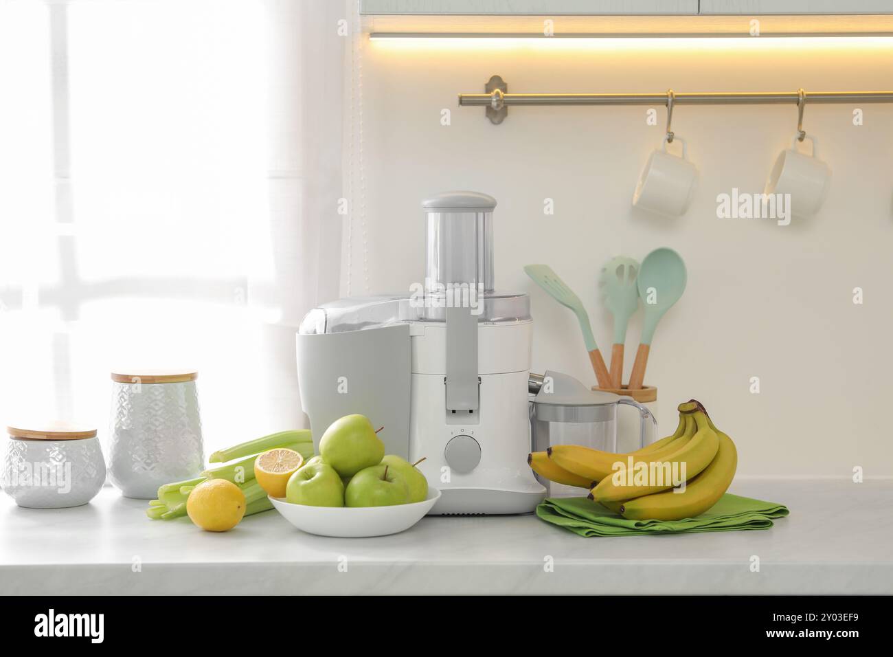 Modern juicer and fruits on white counter in kitchen Stock Photo - Alamy