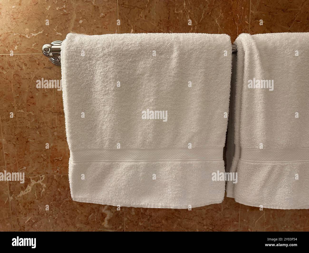 Soft terry towels hanging on tiled wall in hotel bathroom Stock Photo ...
