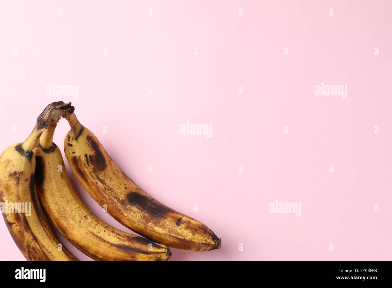 Bunch of ripe bananas with dark spots on pink background, top view ...