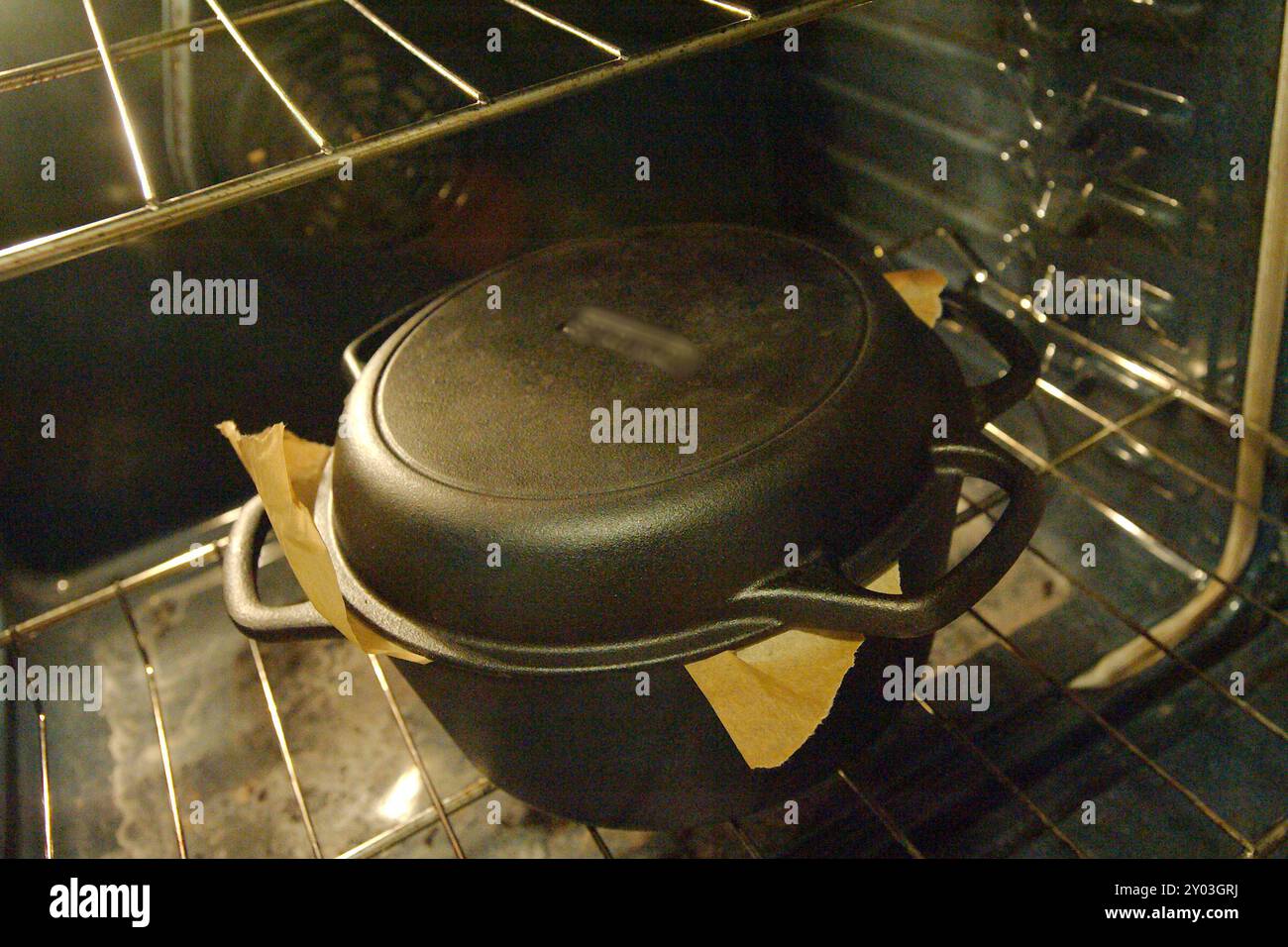 Angled view of a Black Dutch oven lid on with parchment paper in an ...