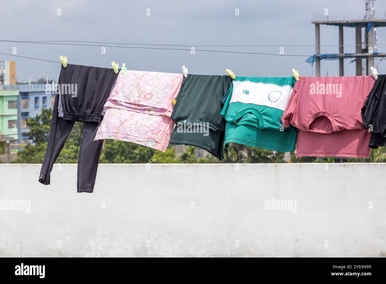 Wet clothes are hanging on a clothesline with clothespins on a rooftop ...