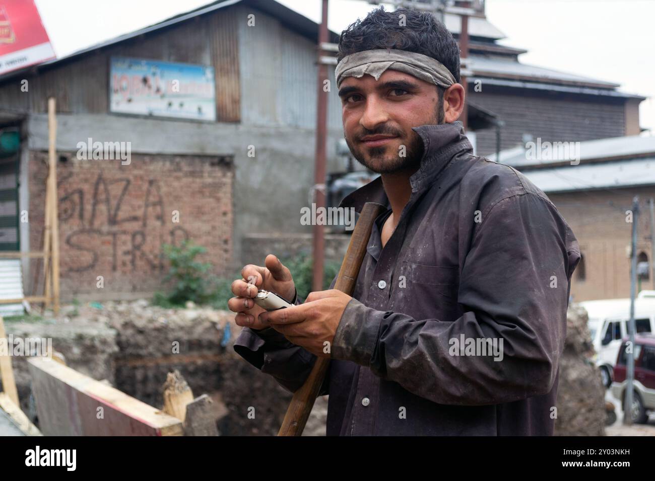 Typical worker checks his cell phone on the streets of Srinagar, India ...