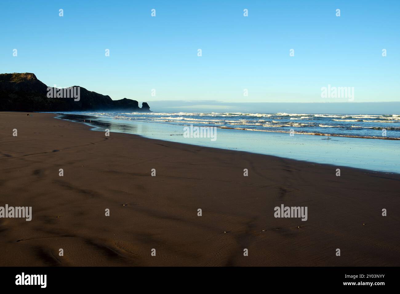 Clear blue sky over breaking waves, before the sin has risen, Auckland ...