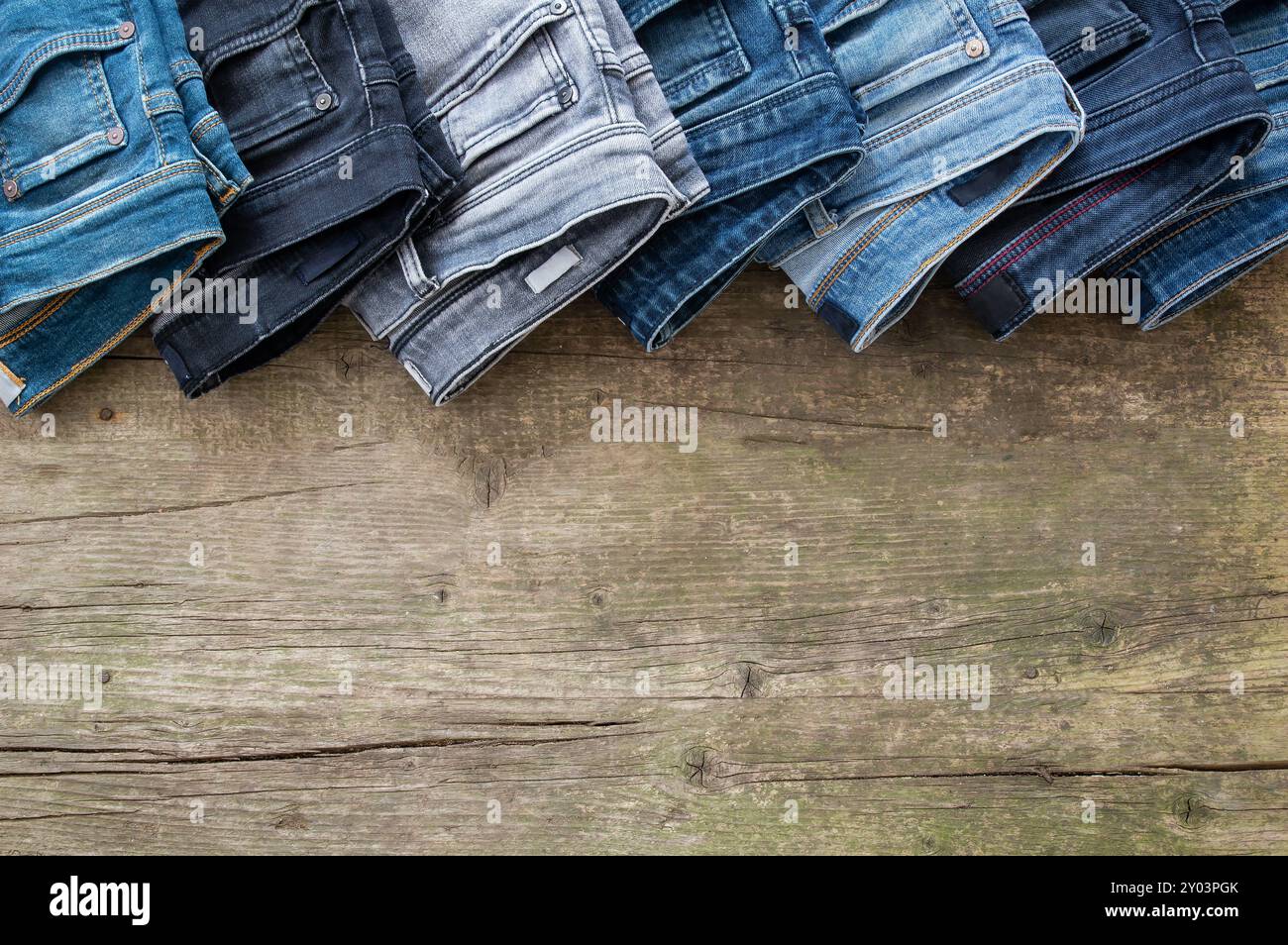 Stack of various denim jeans, trousers on stone rustic background ...