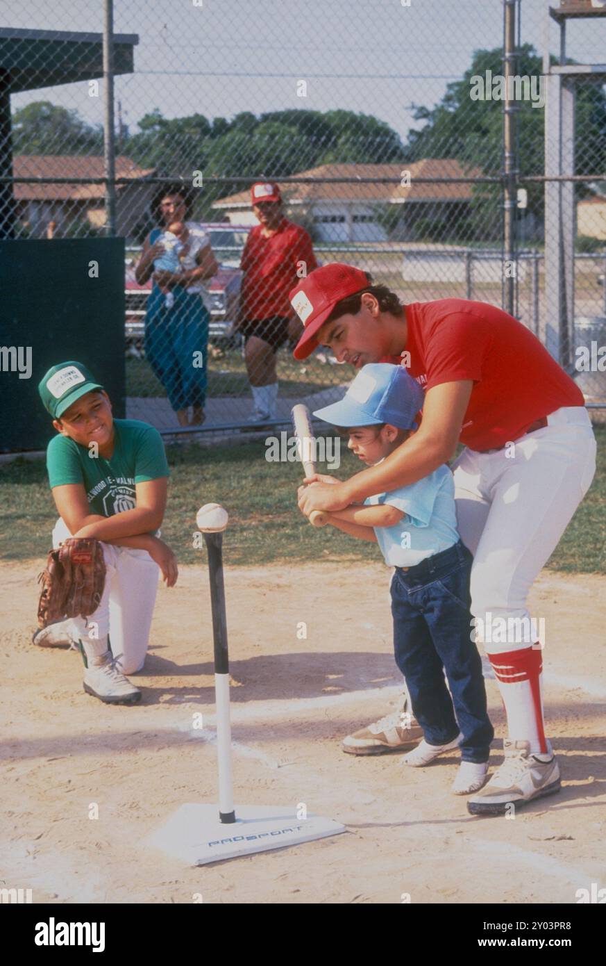 14-year-old brother shows four-year-old little brother how to bat a ...