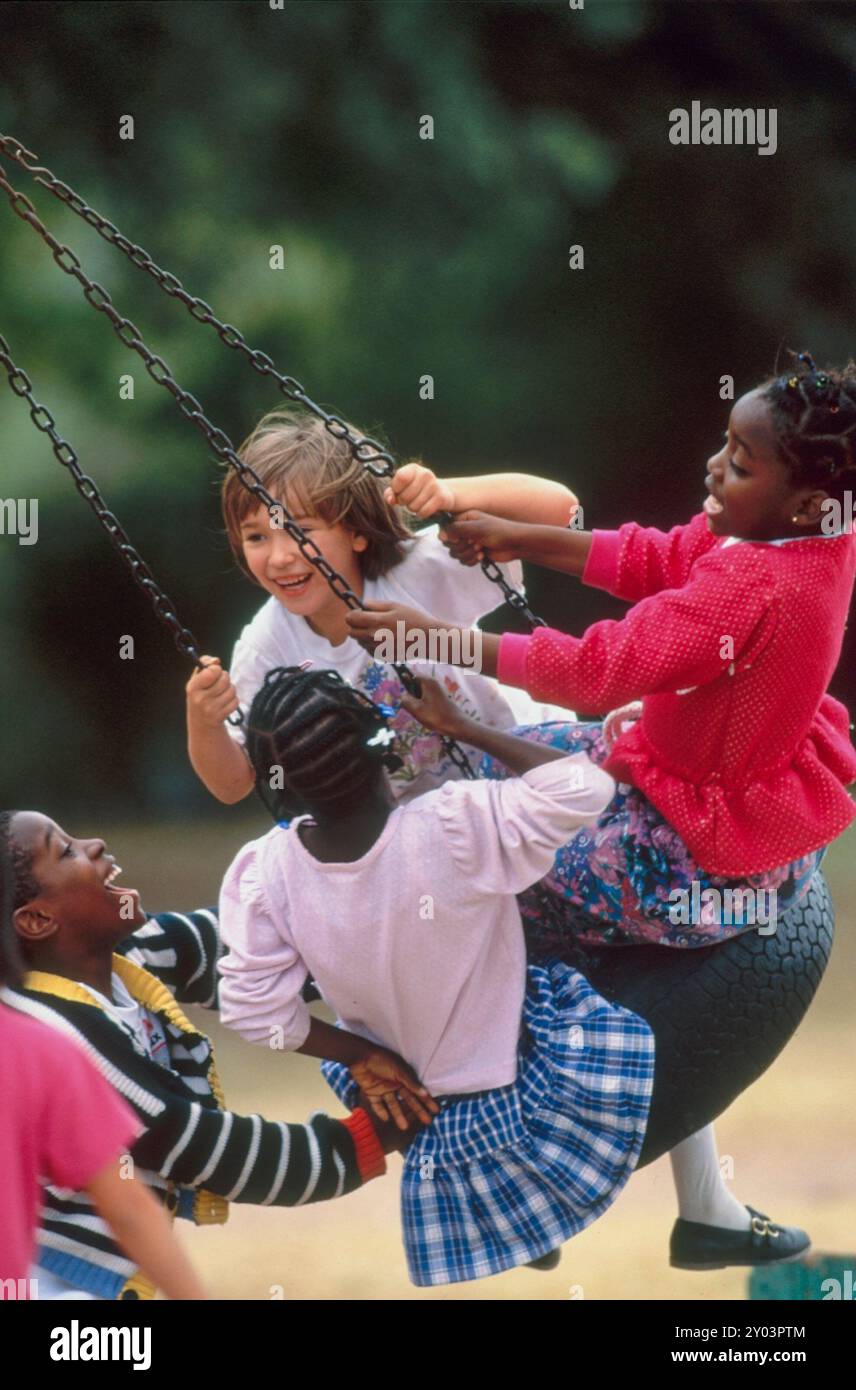 Austin, Texas: Second- and third-grade students play on a tire swing on ...