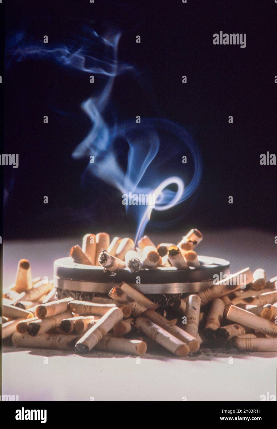 Concept photo illustration of the dangers of smoking with an ash tray ...