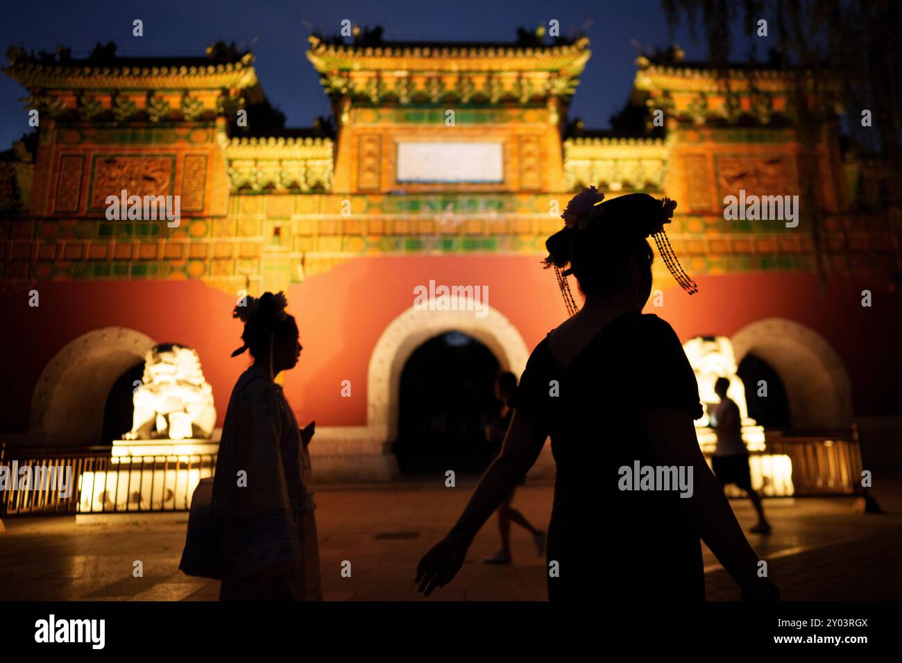 Chinese women dressed in Qing Dynasty attire walk in front of a ...
