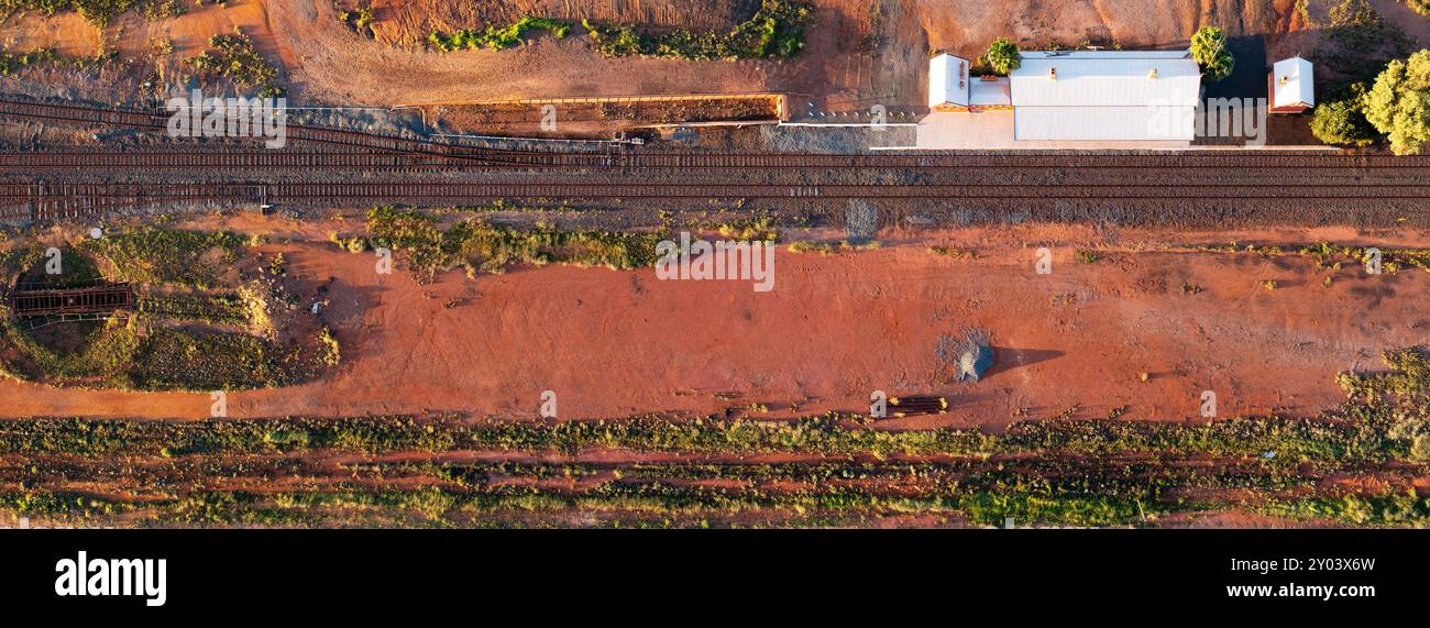 Aerial panorama of a remote railway station and platform on red soil at ...