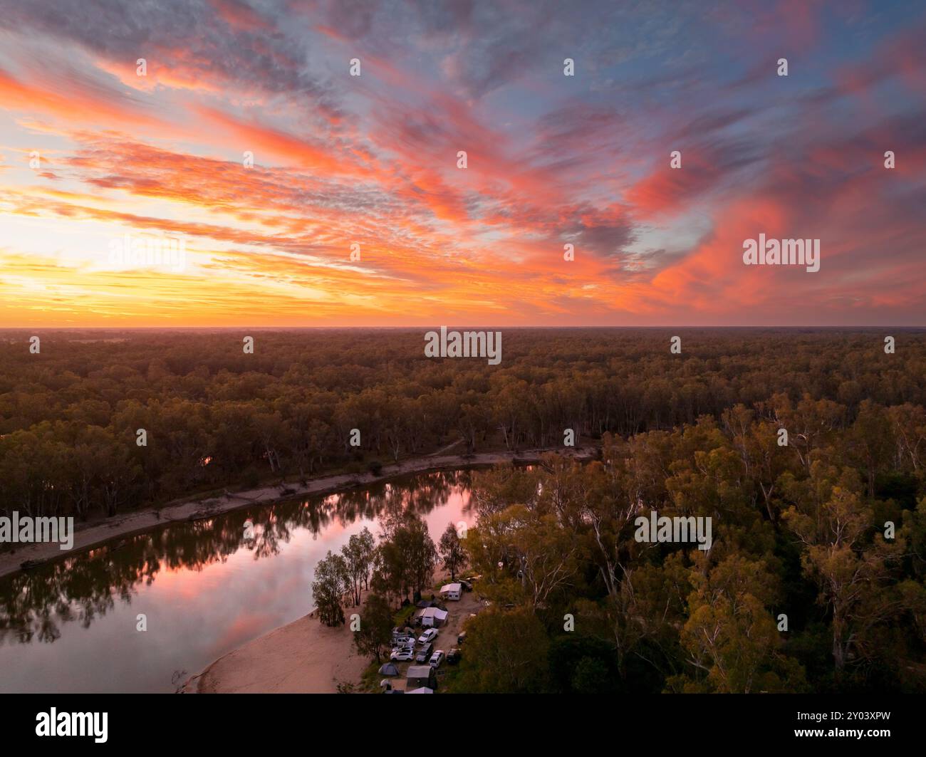 Aerial view of a dramatic colourful sunset sky over bend in a river ...