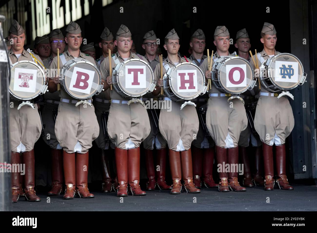 Members the Texas A&M Corps of Cadets band hold up signs that spell out ...