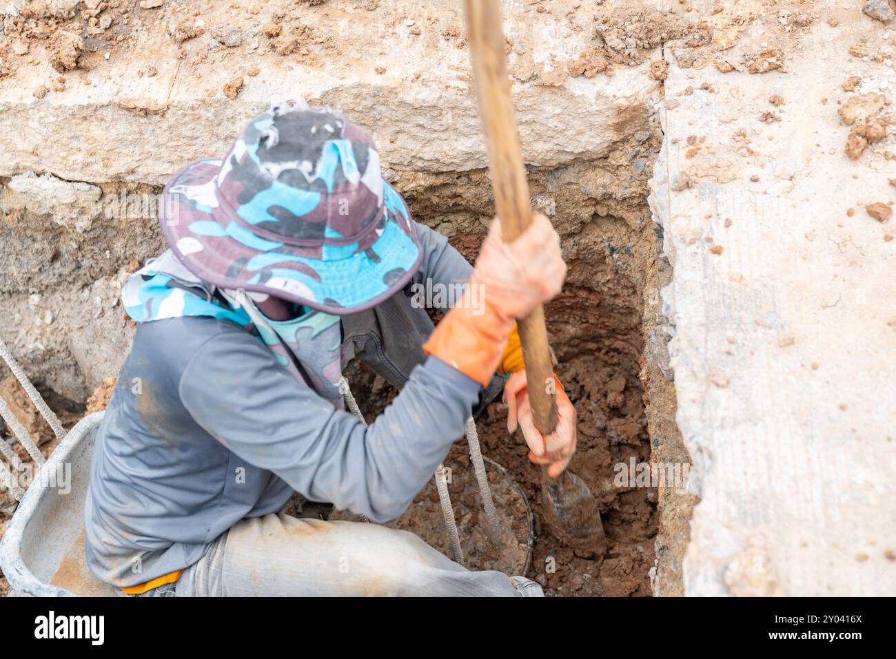 Worker digging pile holes on a construction site. Building house ...
