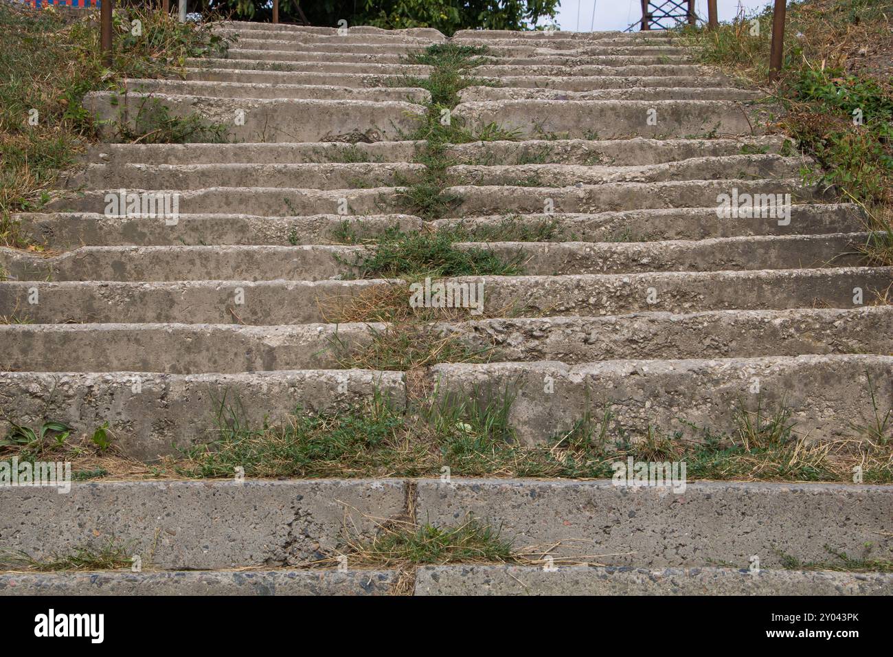 A set of concrete stairs with worn and cracked steps, showing signs of ...