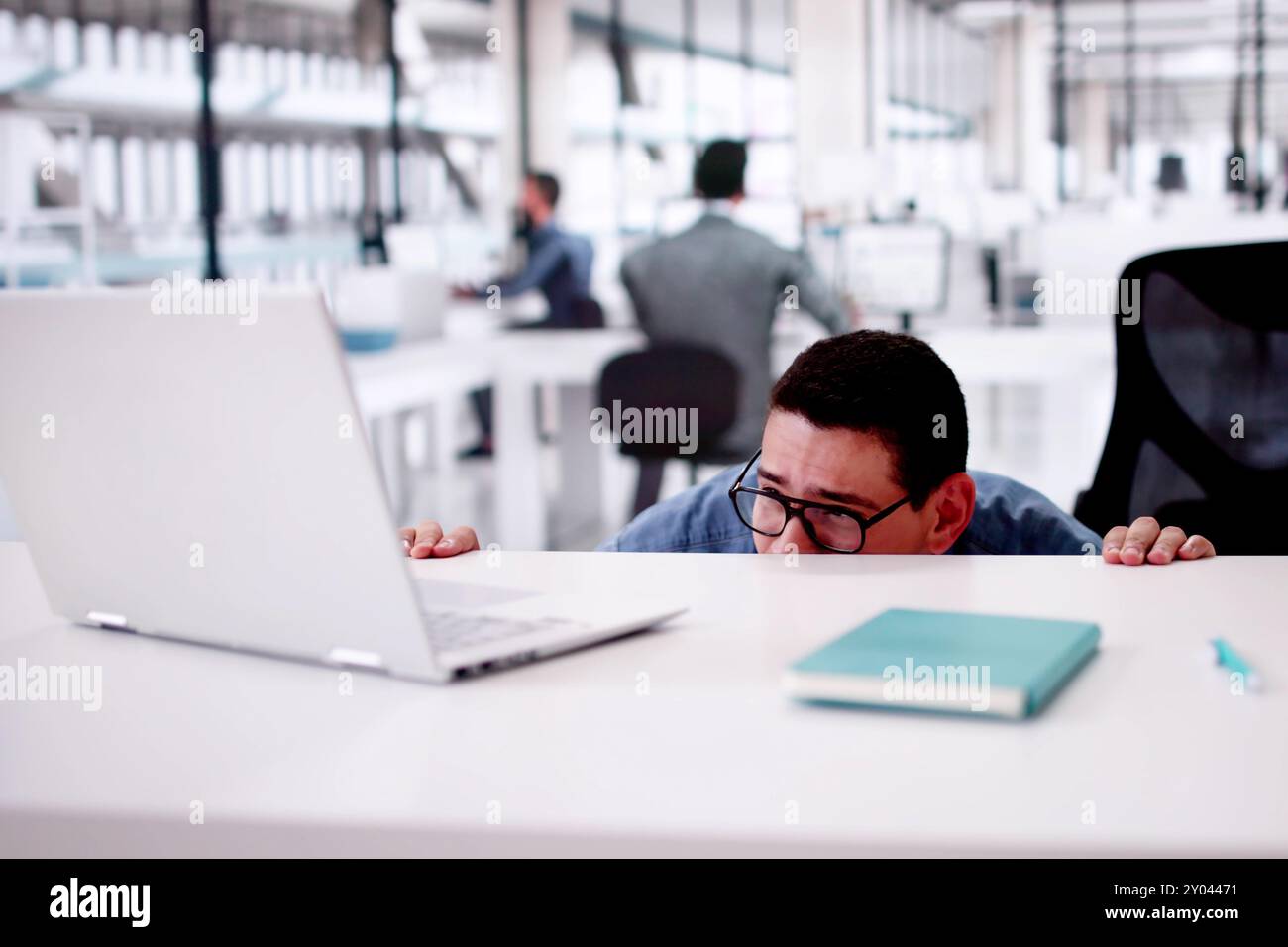 Hiding Behind Desk In Office And Peering Over Stock Photo - Alamy
