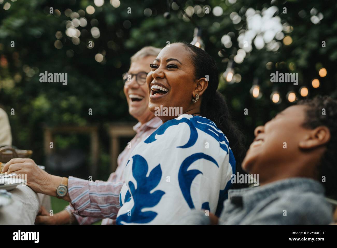 Cheerful woman having fun with male family members at social gathering ...