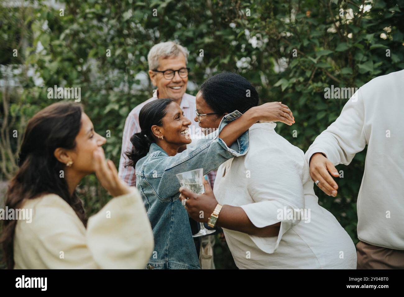 Happy female family members greeting each other at social gathering in ...