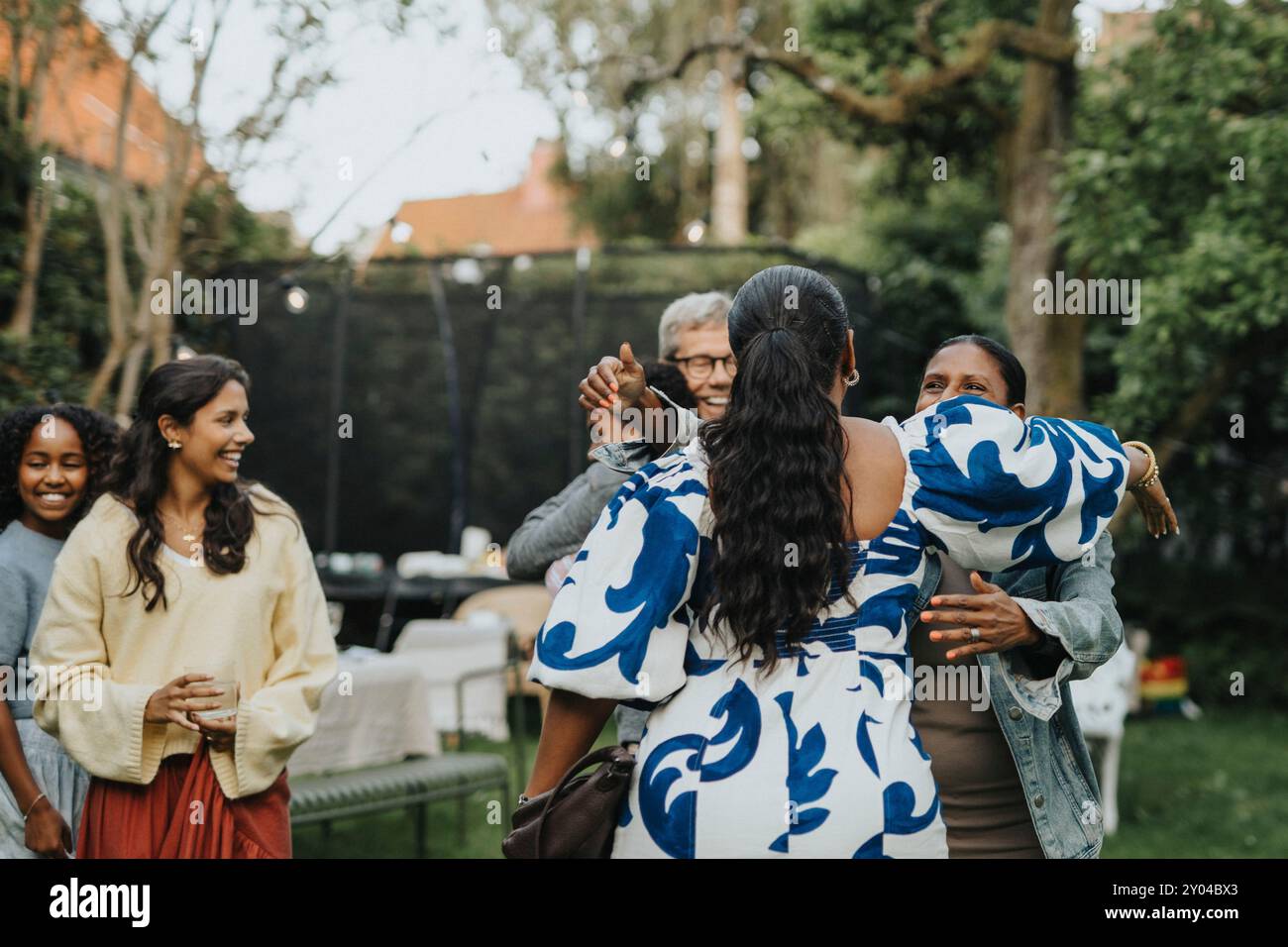 Family members greeting each other during social gathering in back yard ...