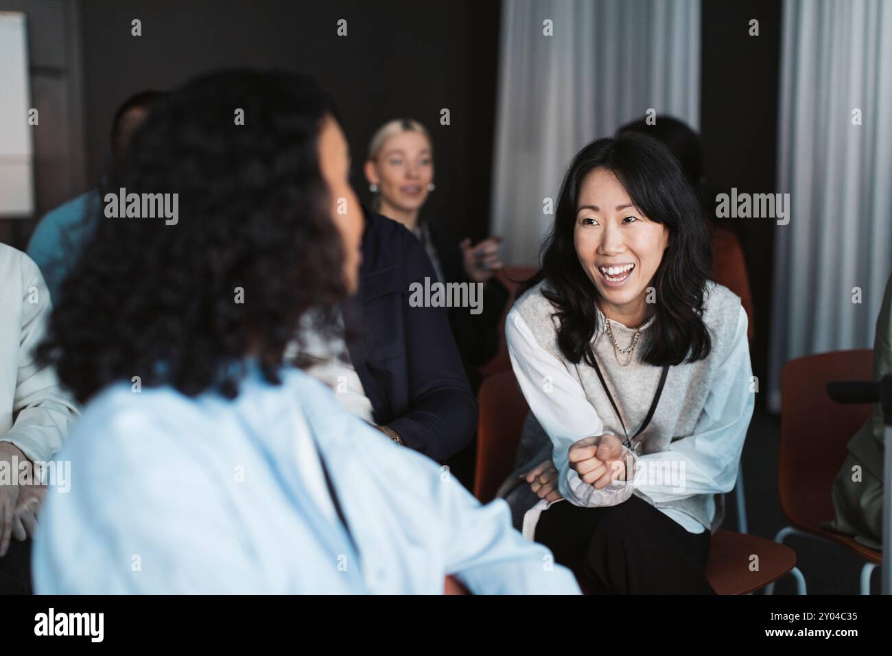 Happy female delegate talking with female entrepreneur during seminar ...