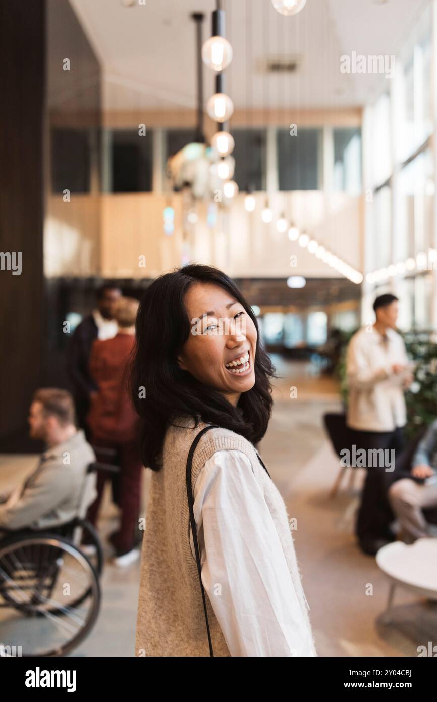 Side view portrait of happy businesswoman laughing while standing in ...