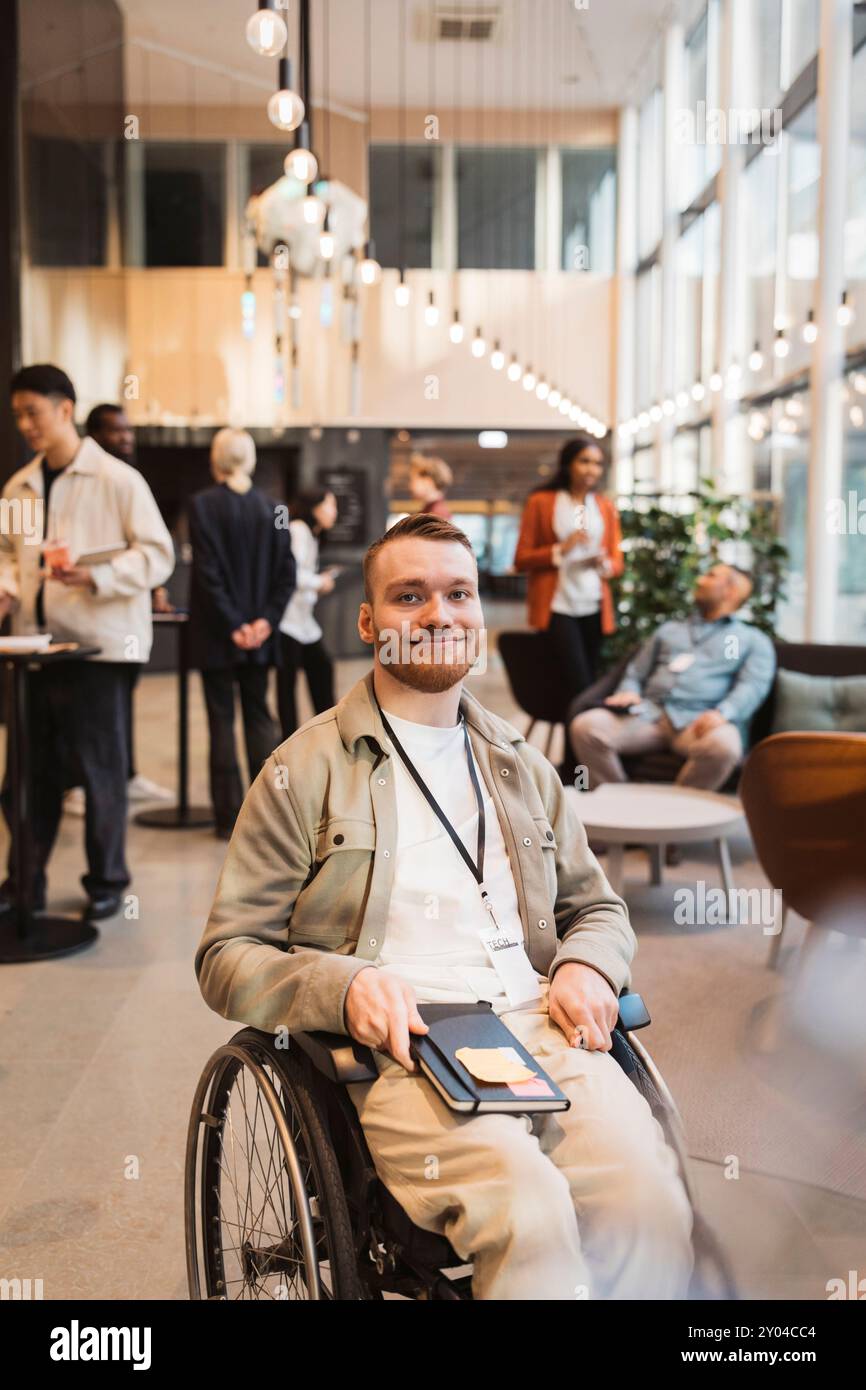 Portrait of smiling male entrepreneur with disability sitting on ...