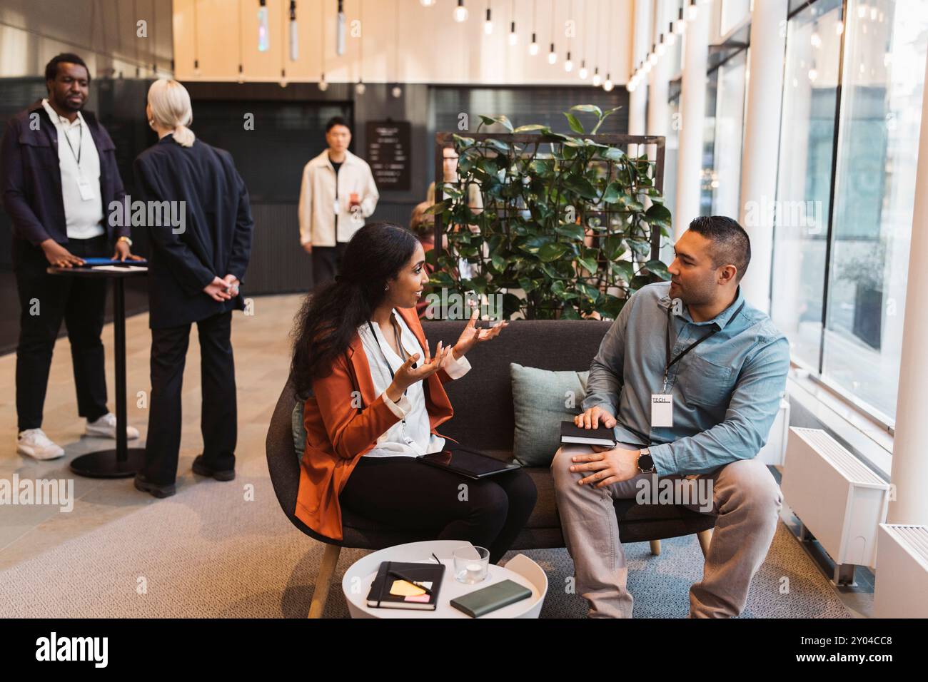 Multiracial male and female delegates discussing business strategies ...