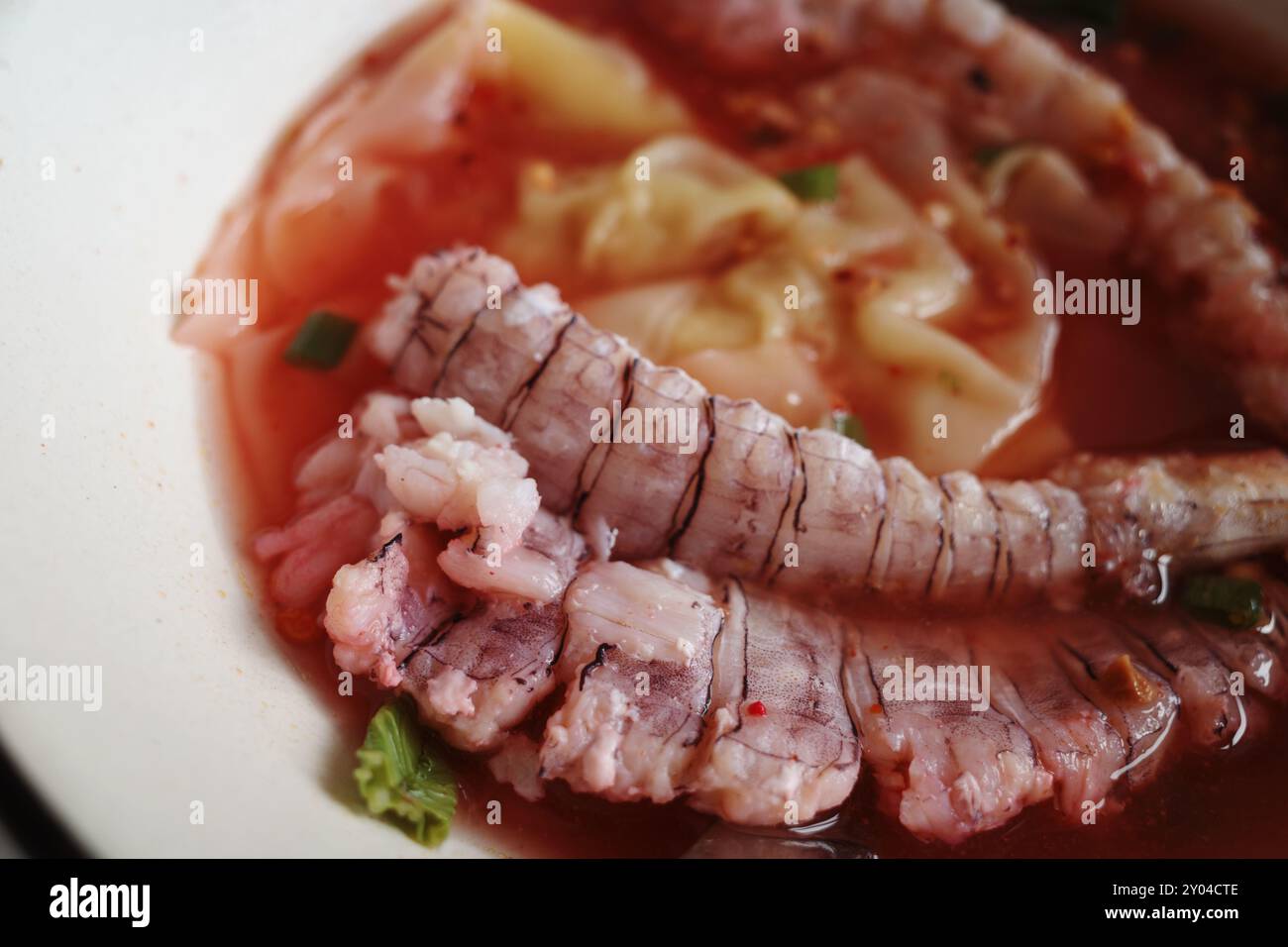 A close-up shot of a mantis shrimp served in a vibrant, spicy yentafo ...