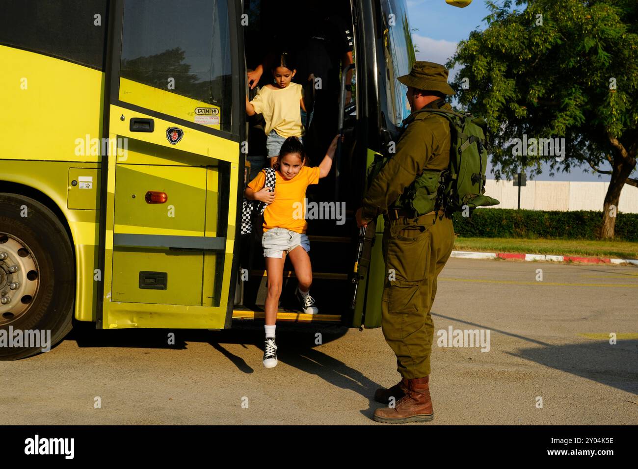 An Israeli soldier stands next to a bus as students arrive at their ...