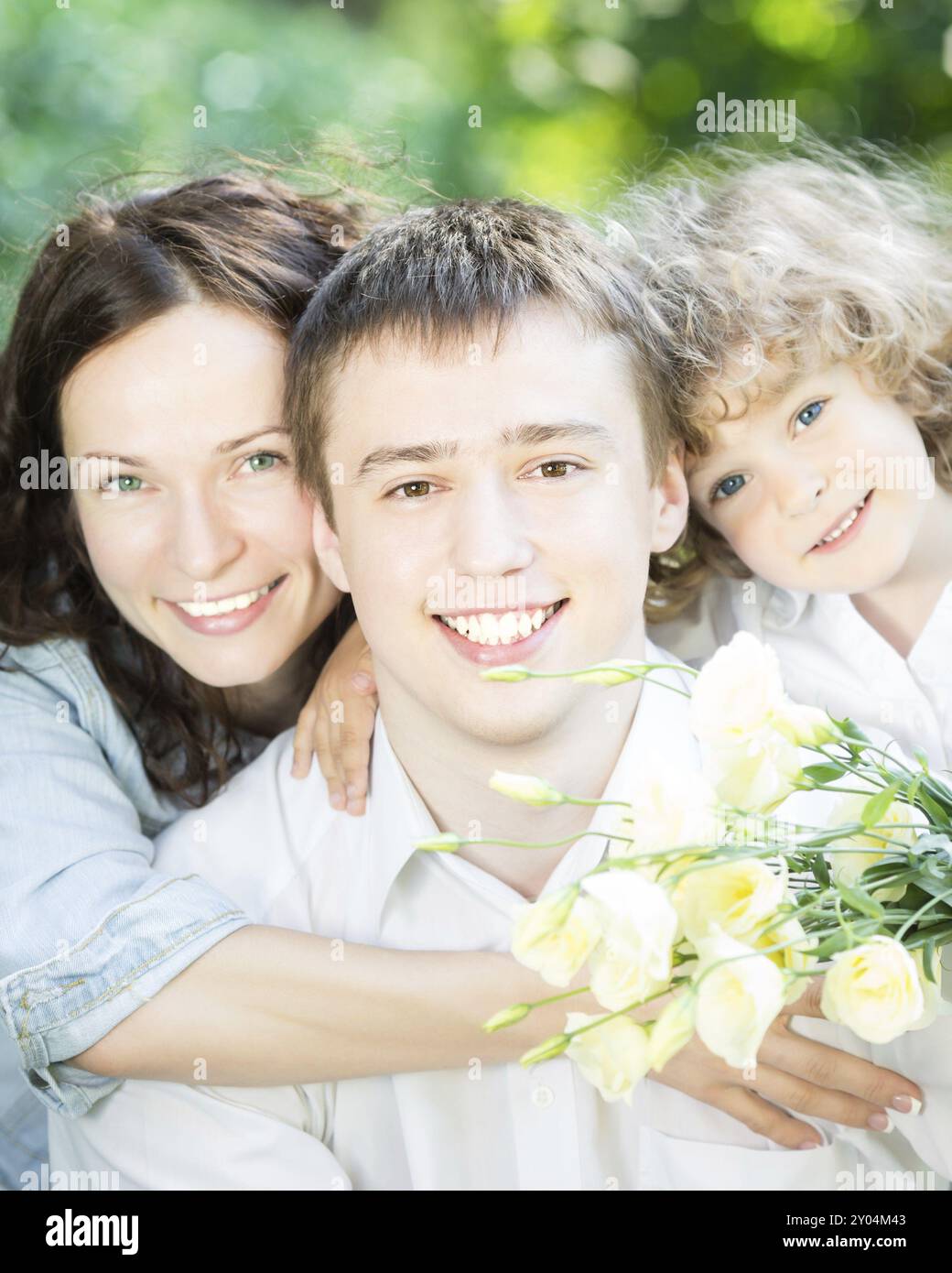Closeup portrait of happy family in spring park against natural green ...