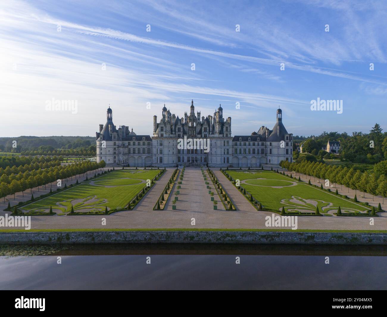 An imposing castle with impressive gardens and symmetrical gravel paths ...
