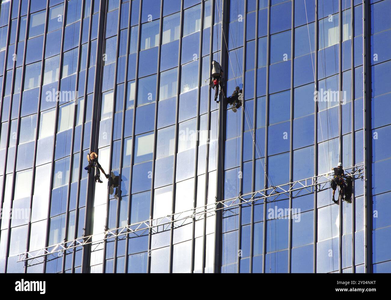 Three window cleaner at a glass facade and blue sky Stock Photo - Alamy