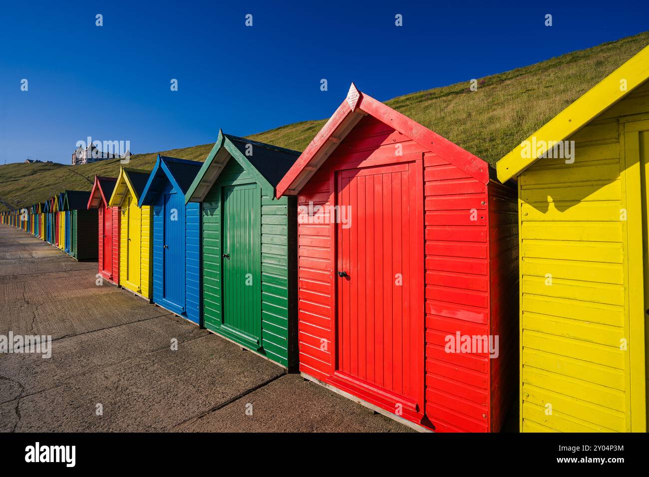The colourful wooden beach huts in Whitby lining the promenade. In the ...