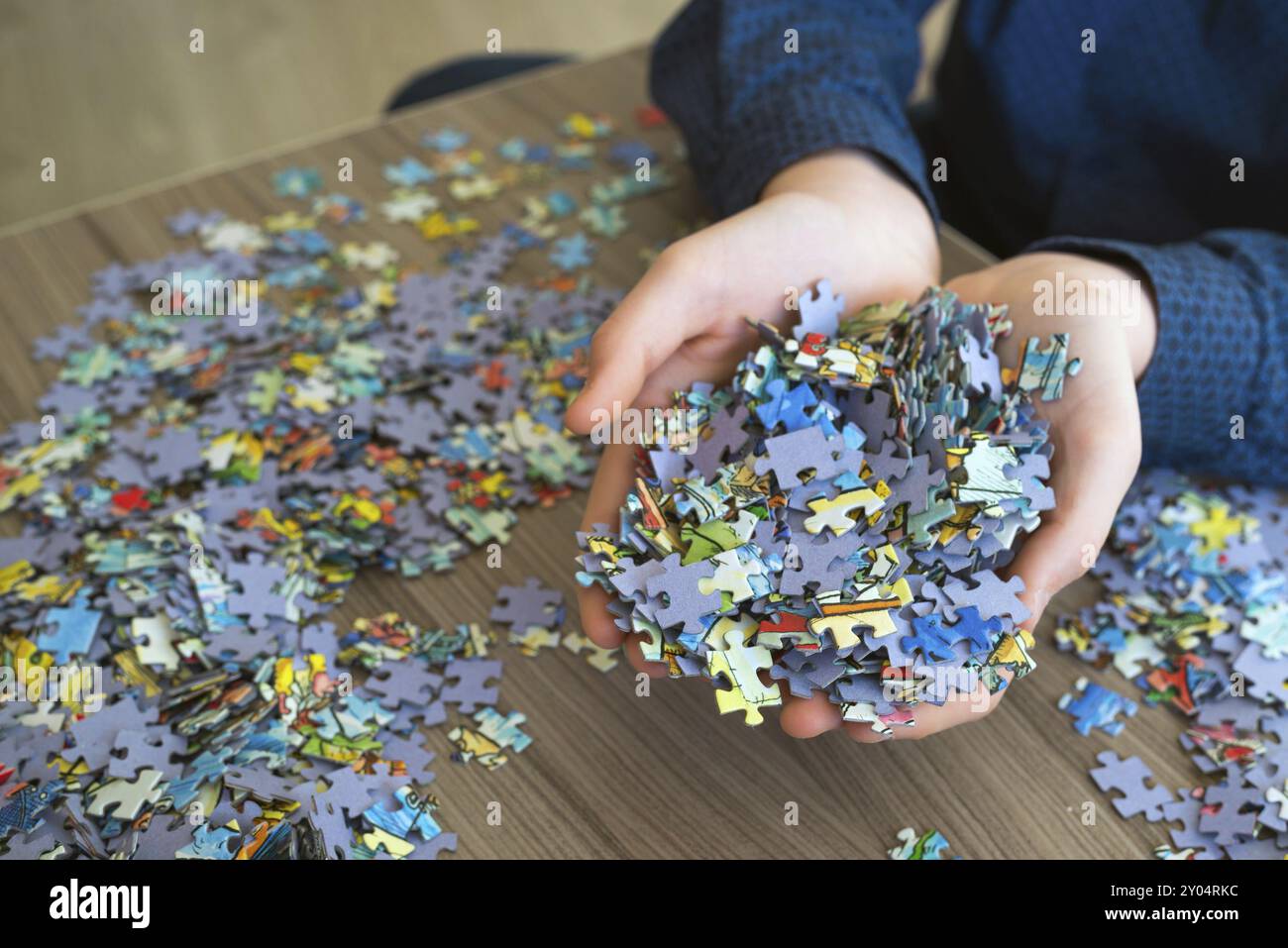Pile of puzzles in the hands of a teenager Stock Photo - Alamy