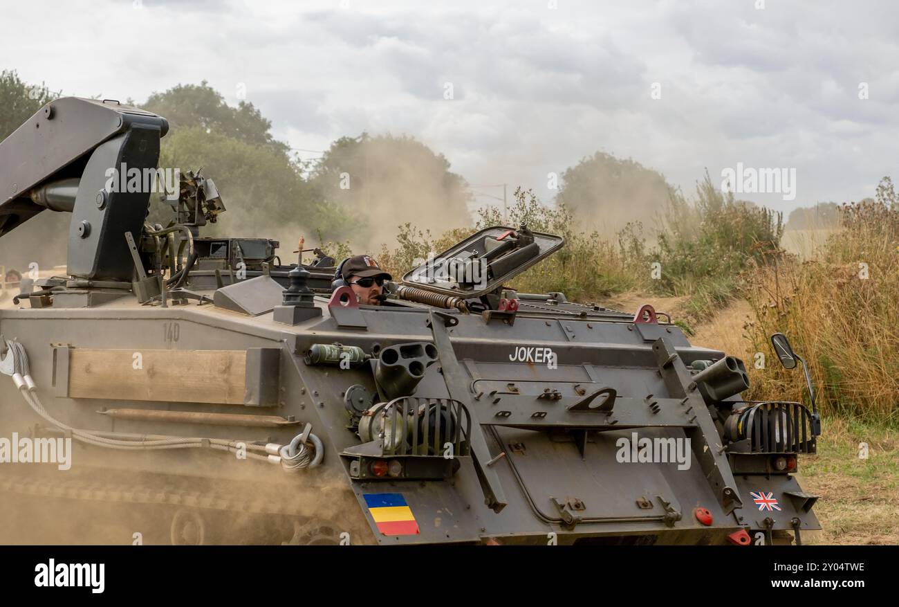 Military tank and off road armoured vehicle driving around a dirt track ...