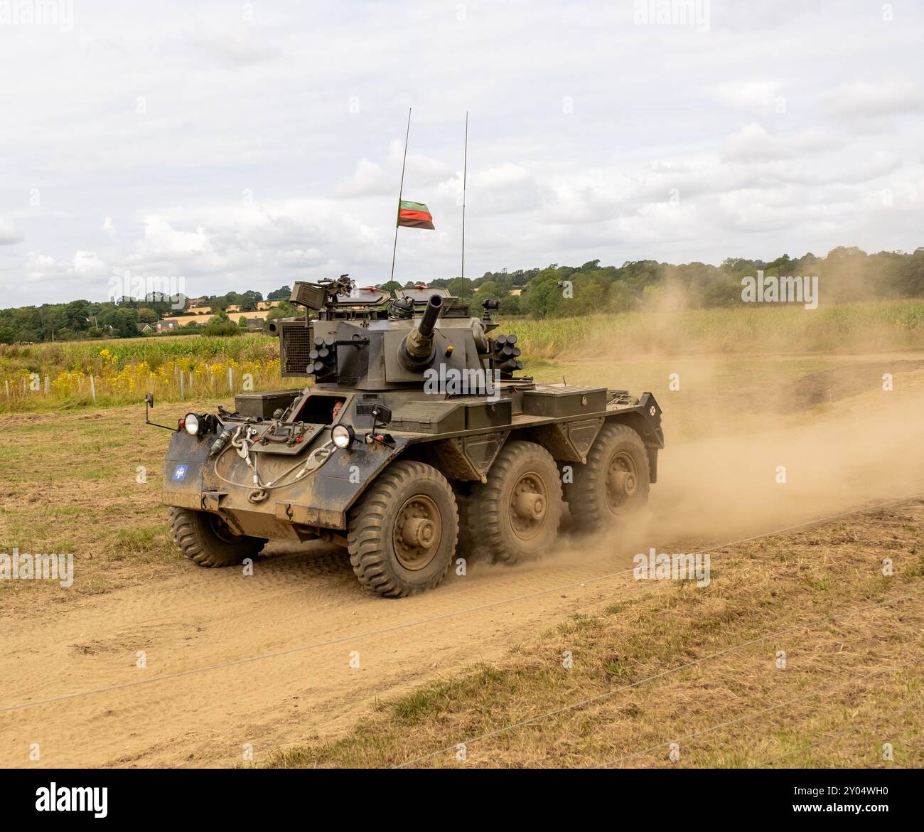 Military tank and off road armoured vehicle driving around a dirt track ...
