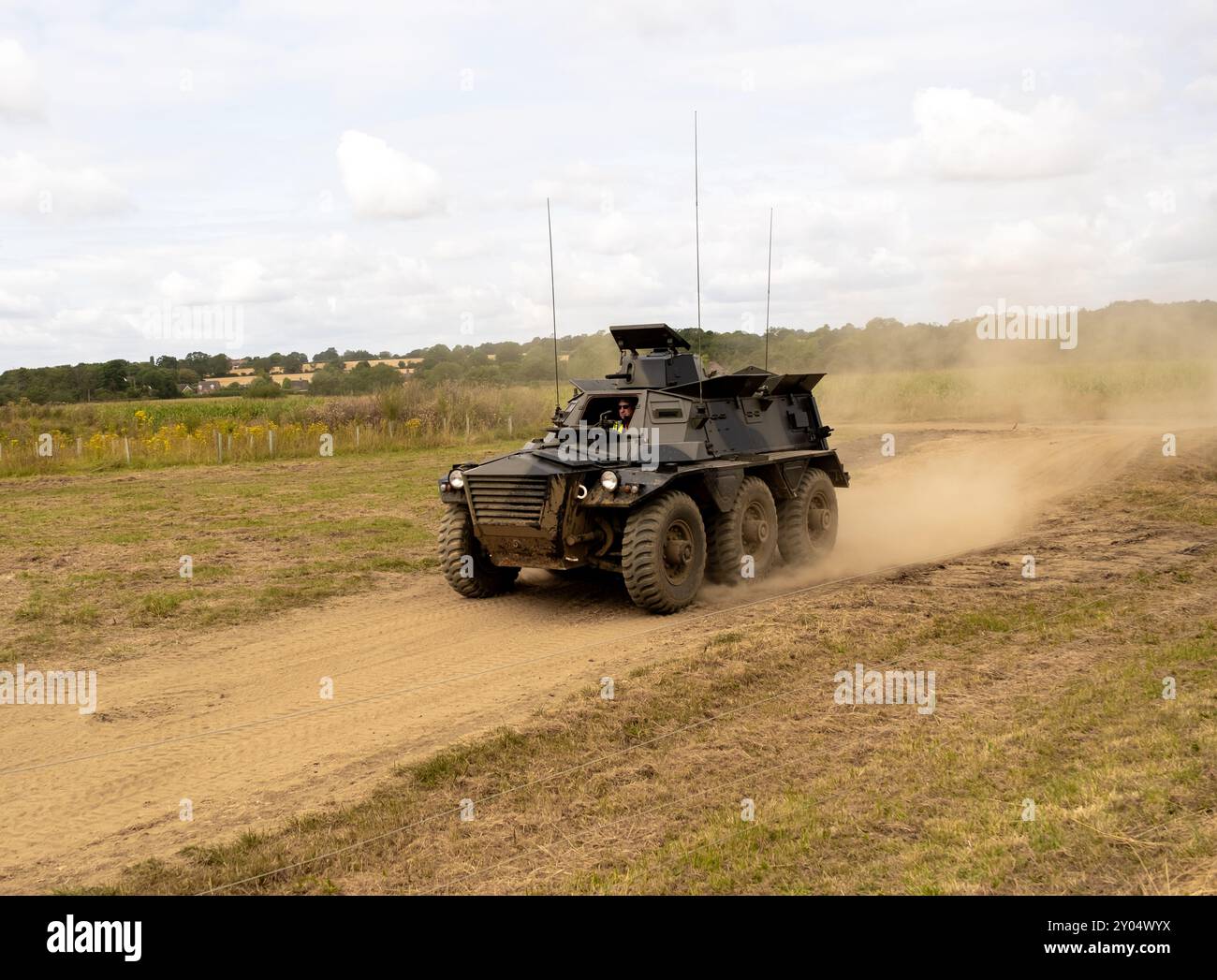 Military tank and off road armoured vehicle driving around a dirt track ...