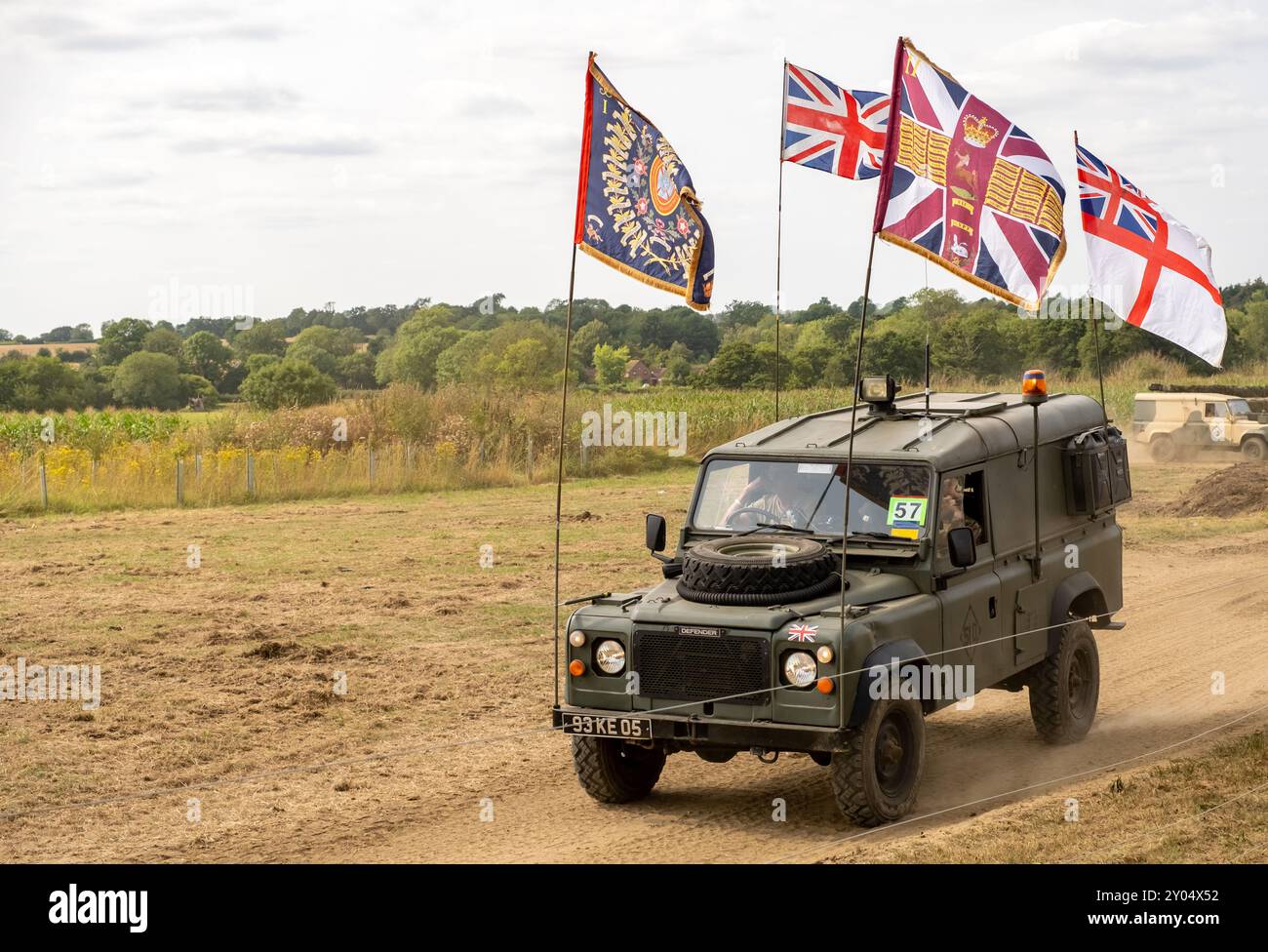 Military Land Rover and off road vehicle driving around a dusty track ...
