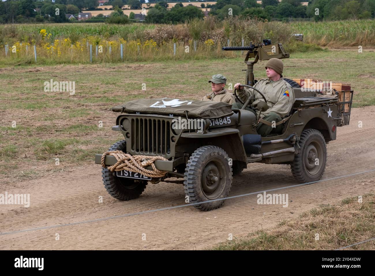 Two young men dressed as soldiers driving around in a military jeep on ...