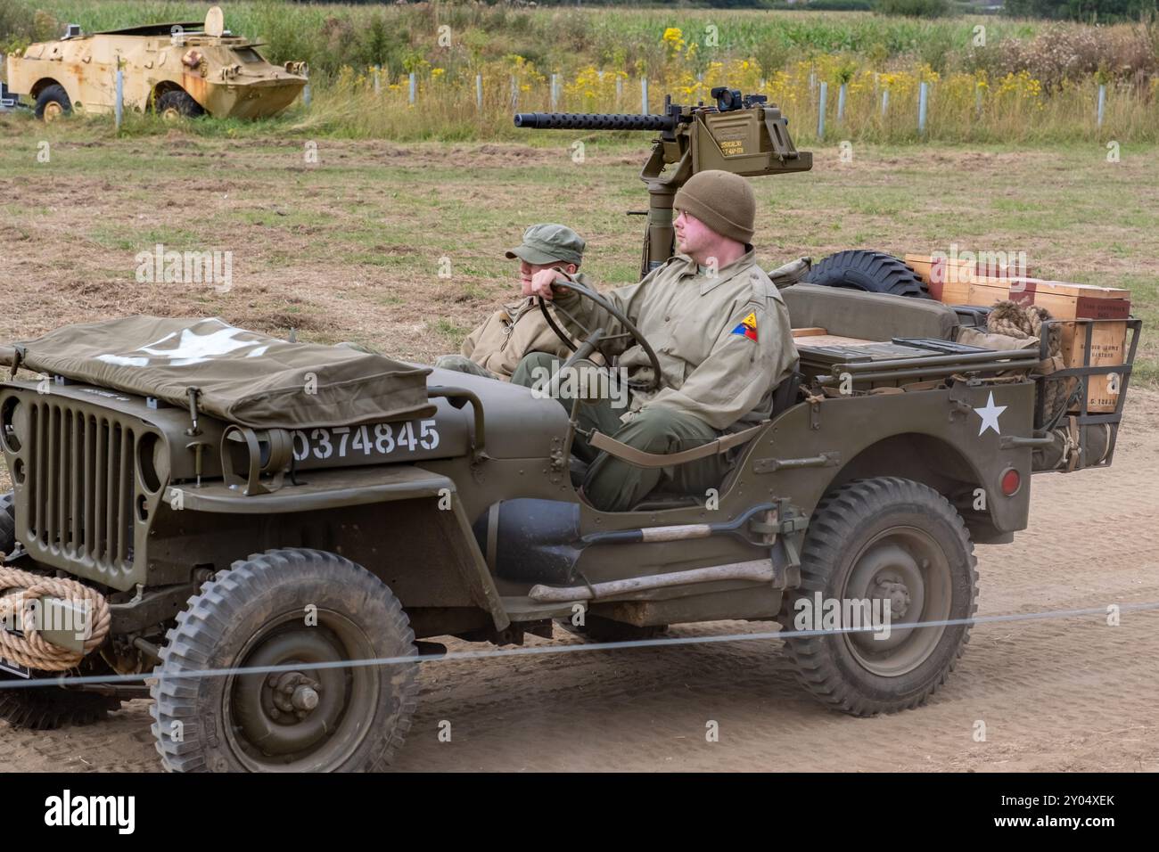 Two young men dressed as soldiers driving around in a military jeep on ...