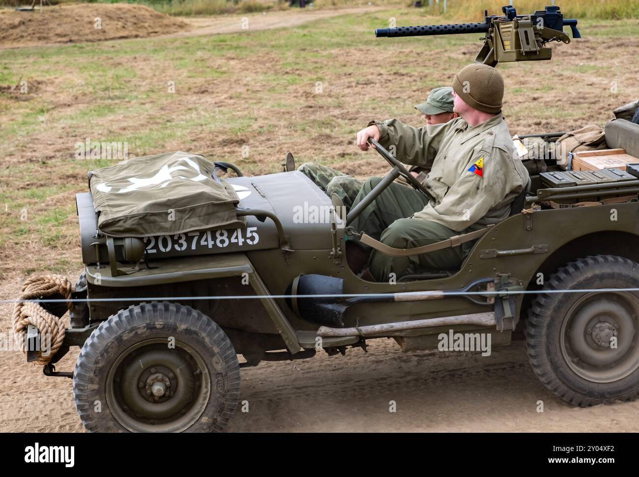 Two young men dressed as soldiers driving around in a military jeep on ...